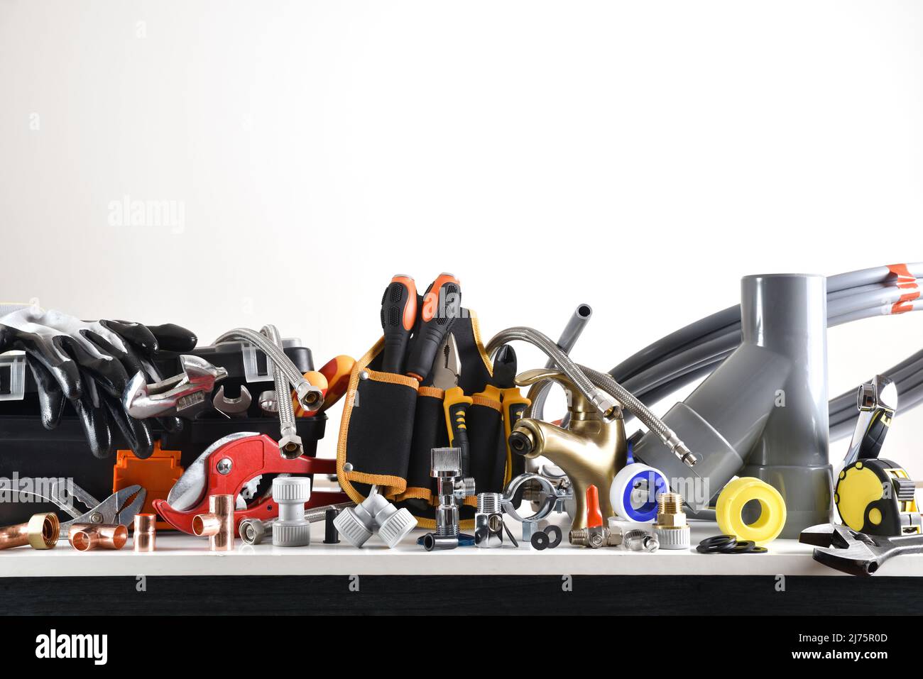 Sample of plumbing materials and tools on workbench and white isolated ...