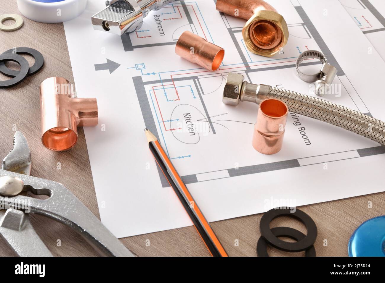 Plans and housing water installation material on wooden table. Elevated ...