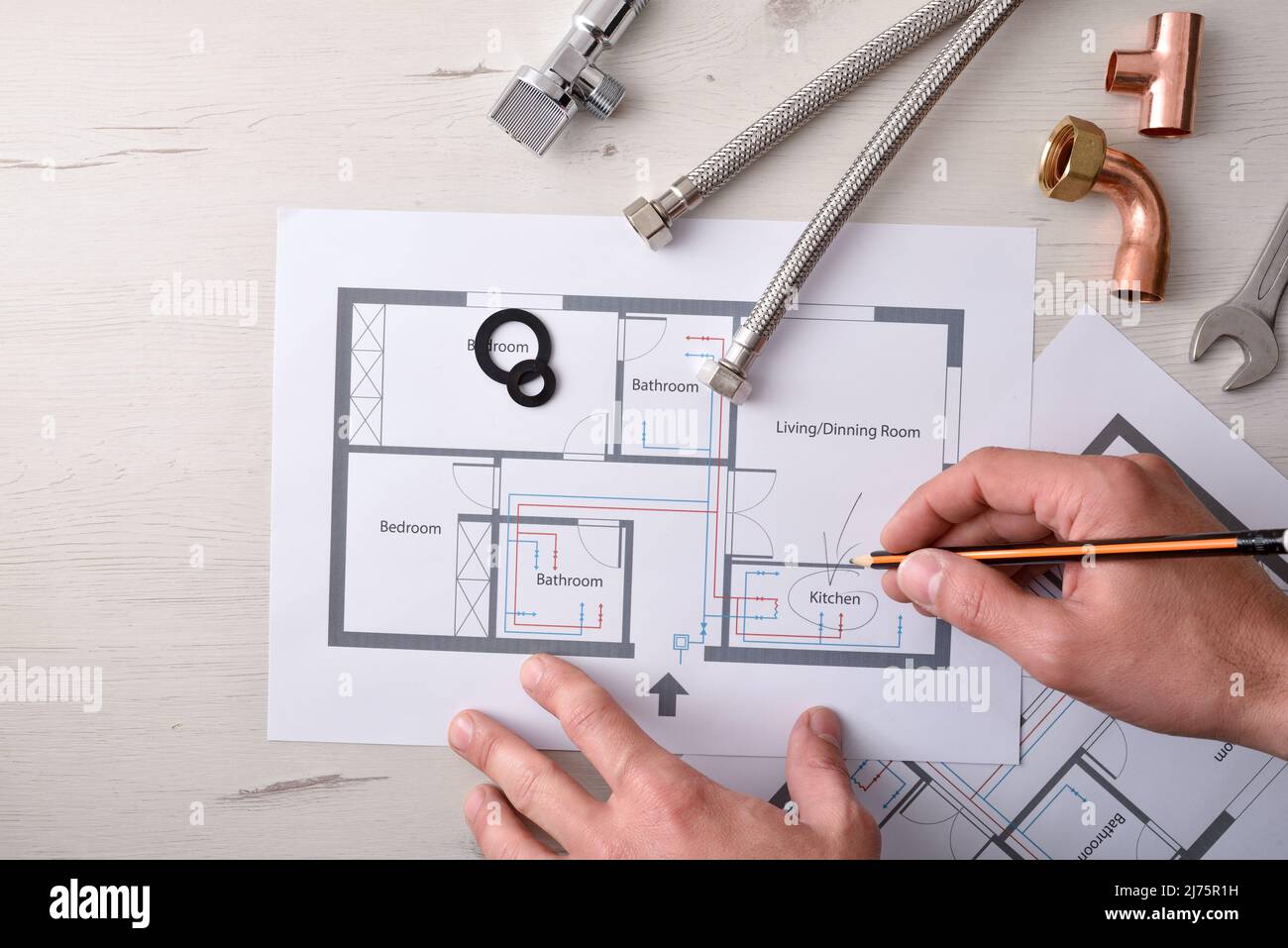 Plumbing technician making notes on a plan of a water installation of a ...