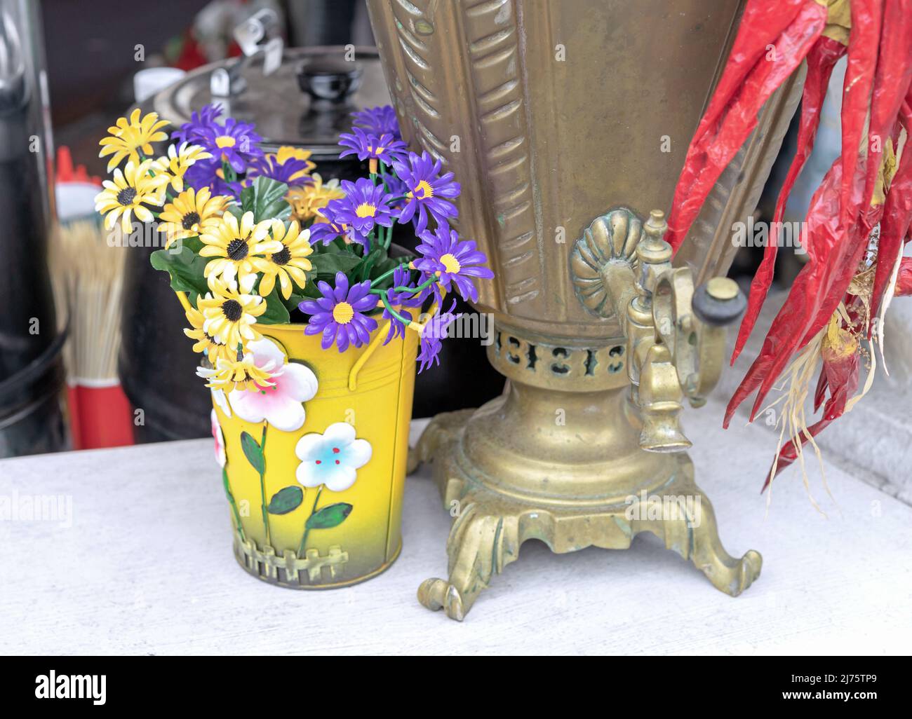 Antique brass samovar and cachepot with yellow and purple summer ...