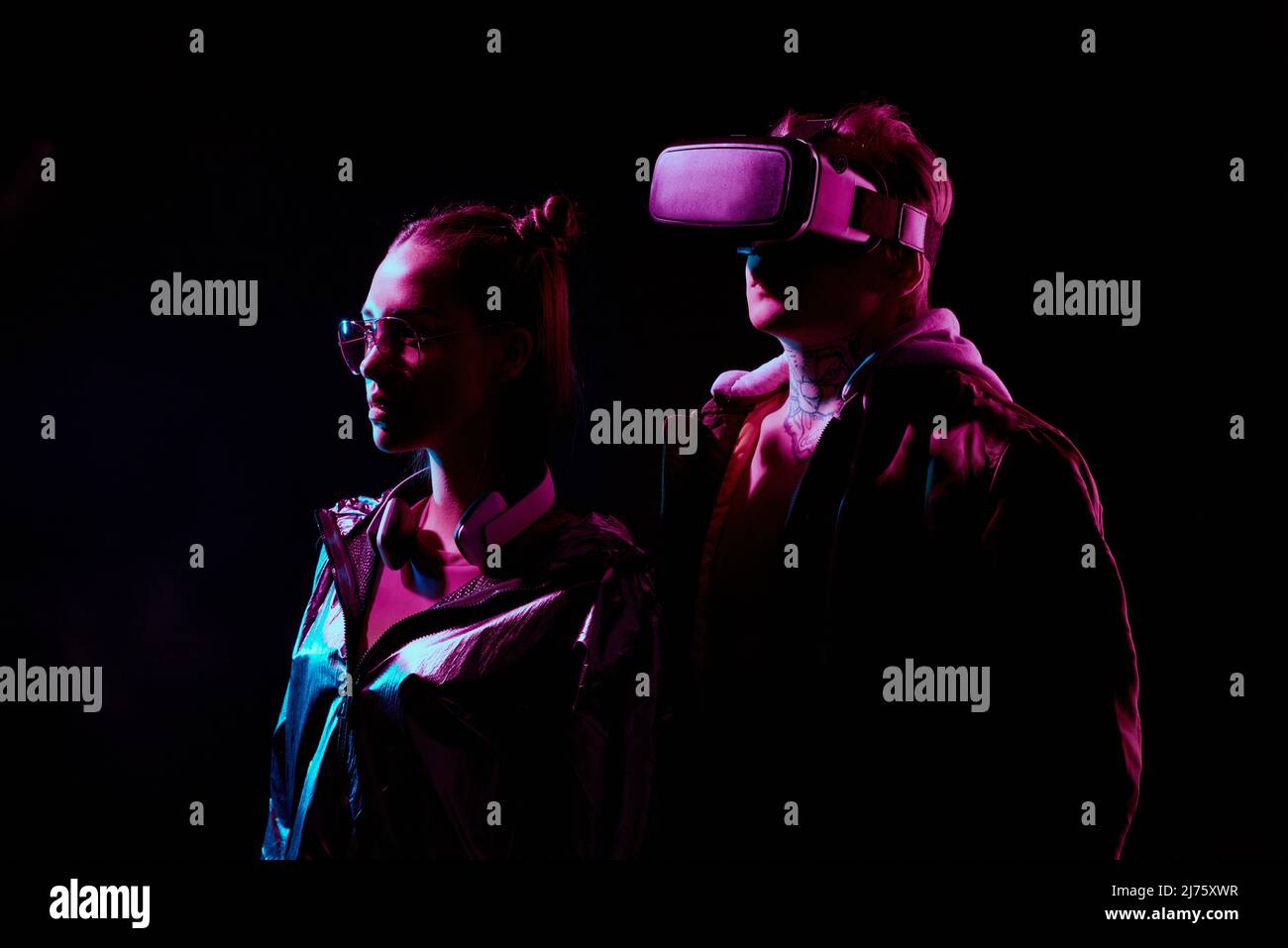 Side view of serious young couple using virtual reality simulator in ...