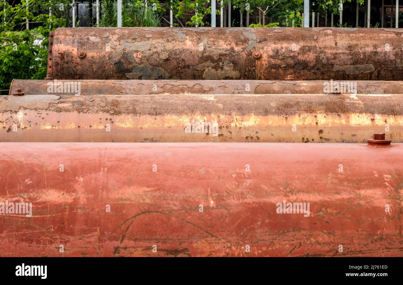A pile of old rustic water cylinders or tanks on the ground close up ...