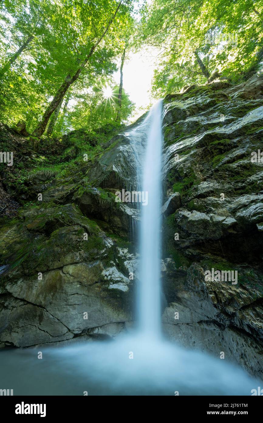 One of the Kesselbach waterfalls with green forest and sun with ...