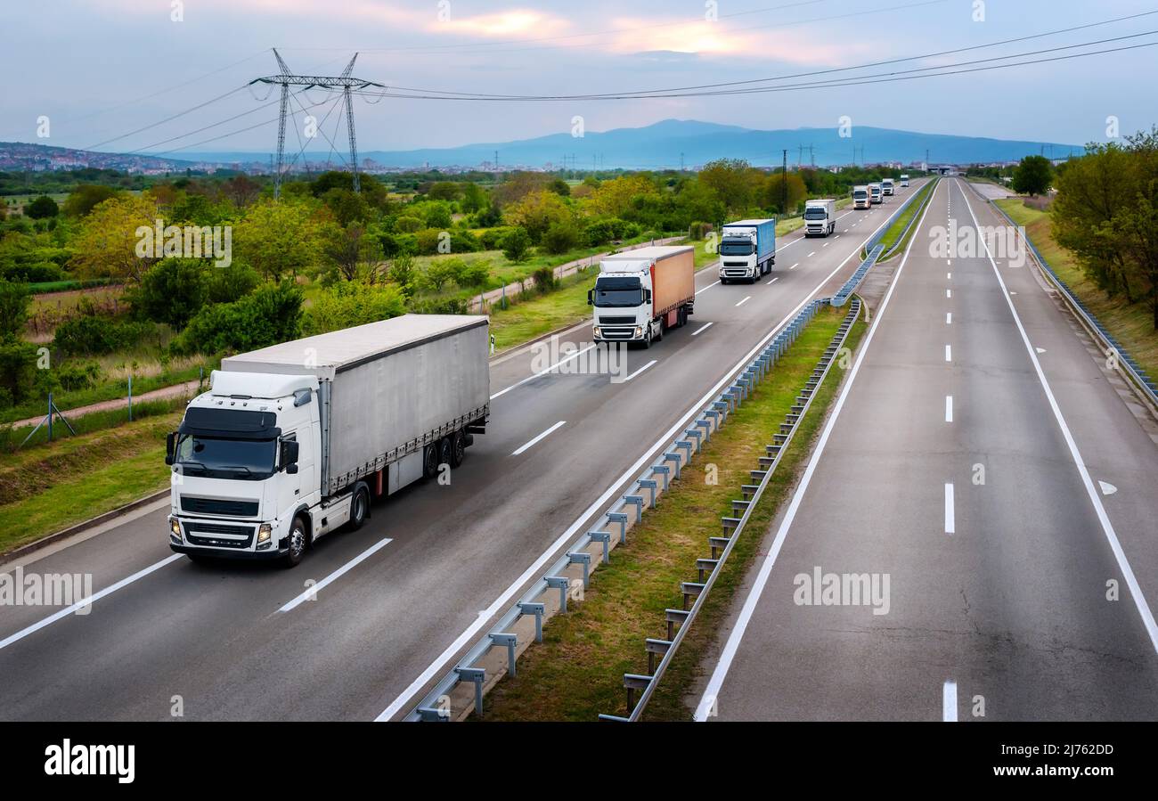 Long convoy of trucks in line on a country highway. Caravan or convoy ...