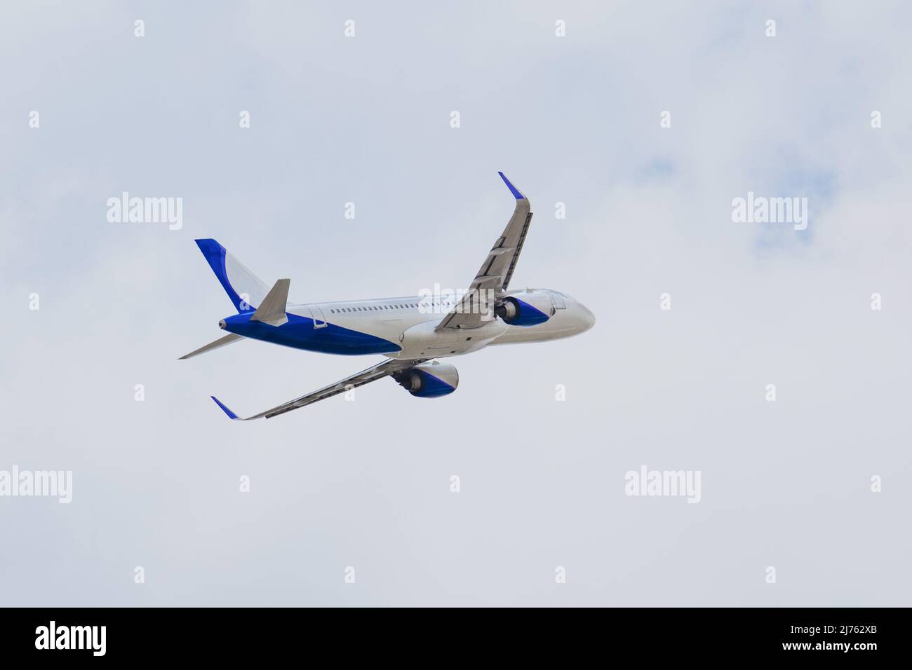 White- blue passenger airplane flying in the sky amazing clouds in the ...