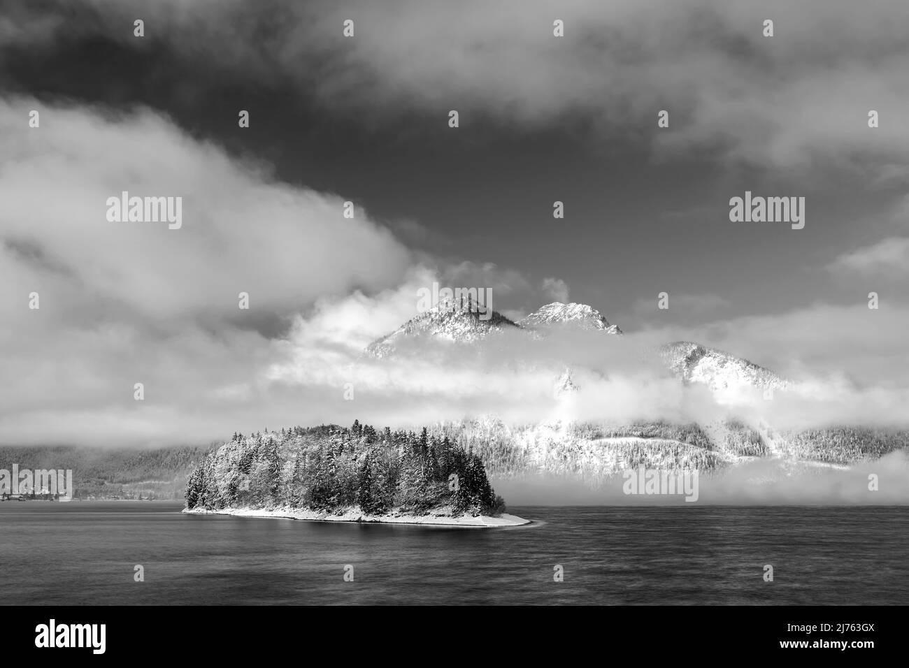 The small island of Sassau in Walchensee in the Byrian Alps covered ...