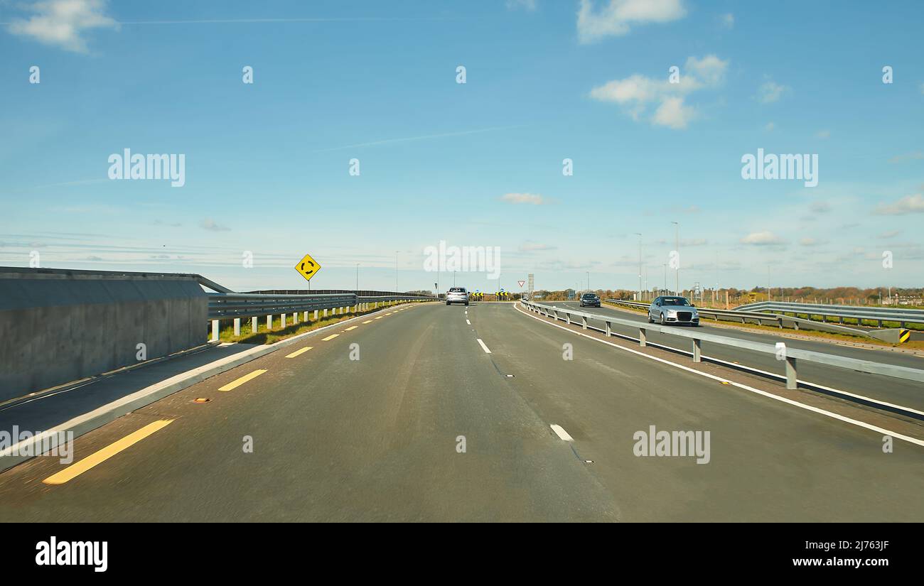 Rear view of cars driving on motorway, Ireland. Road with metal safety ...
