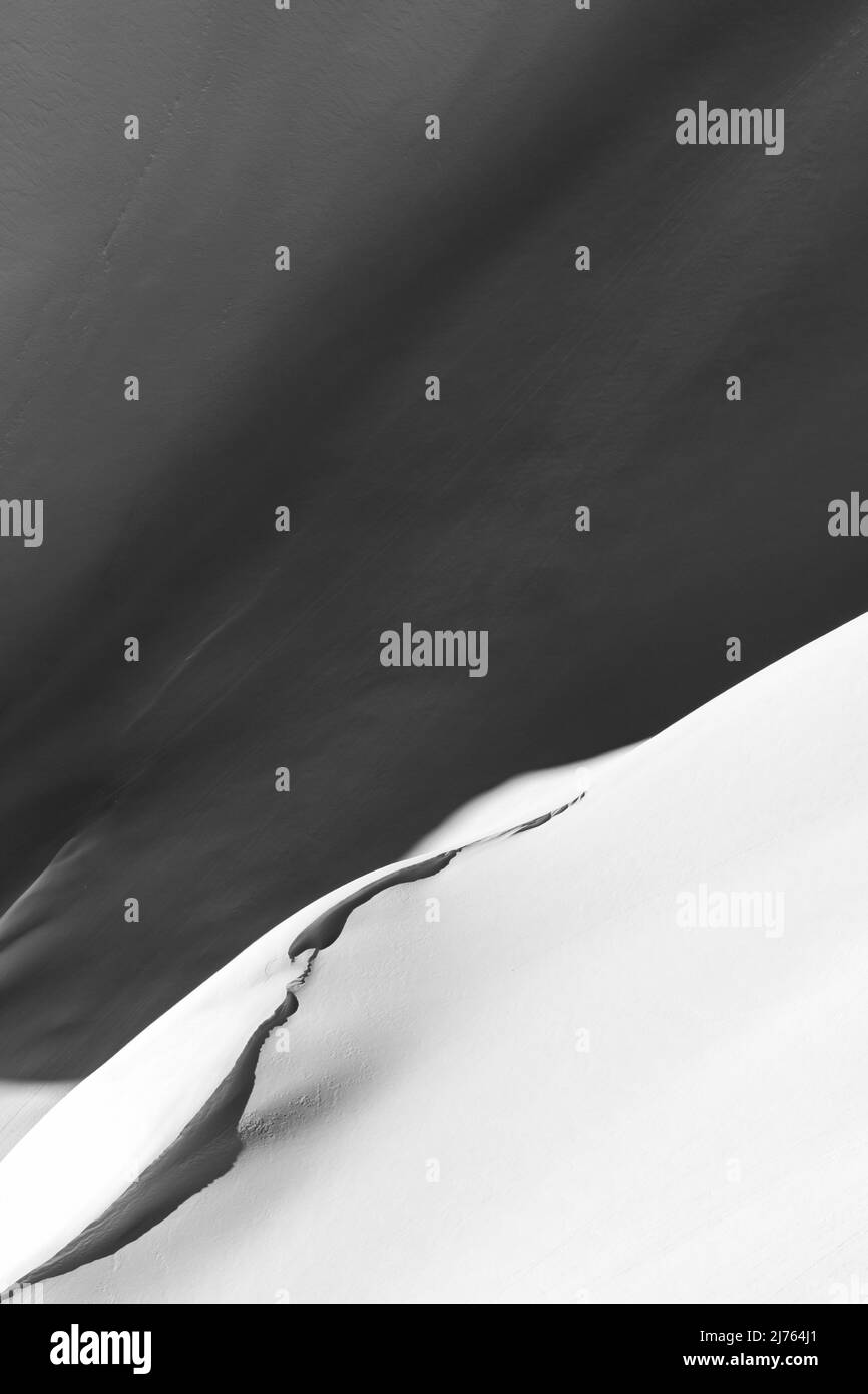 A dune, or wave of snow and ice, with light and shadow on the slopes of ...