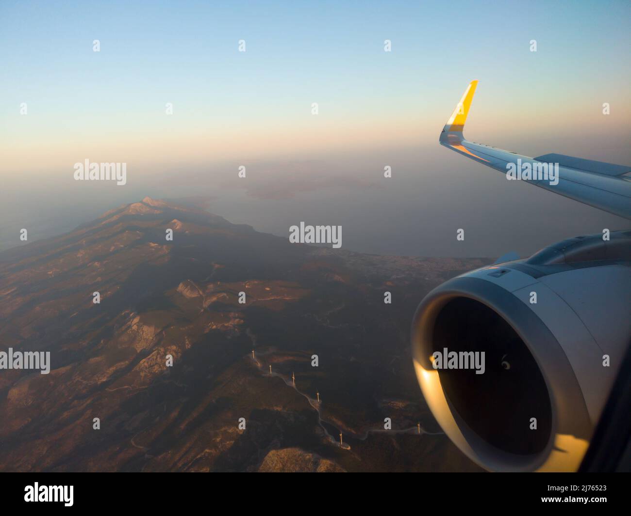 Airplane wing with engine out of window. Flight over land on sunrise ...