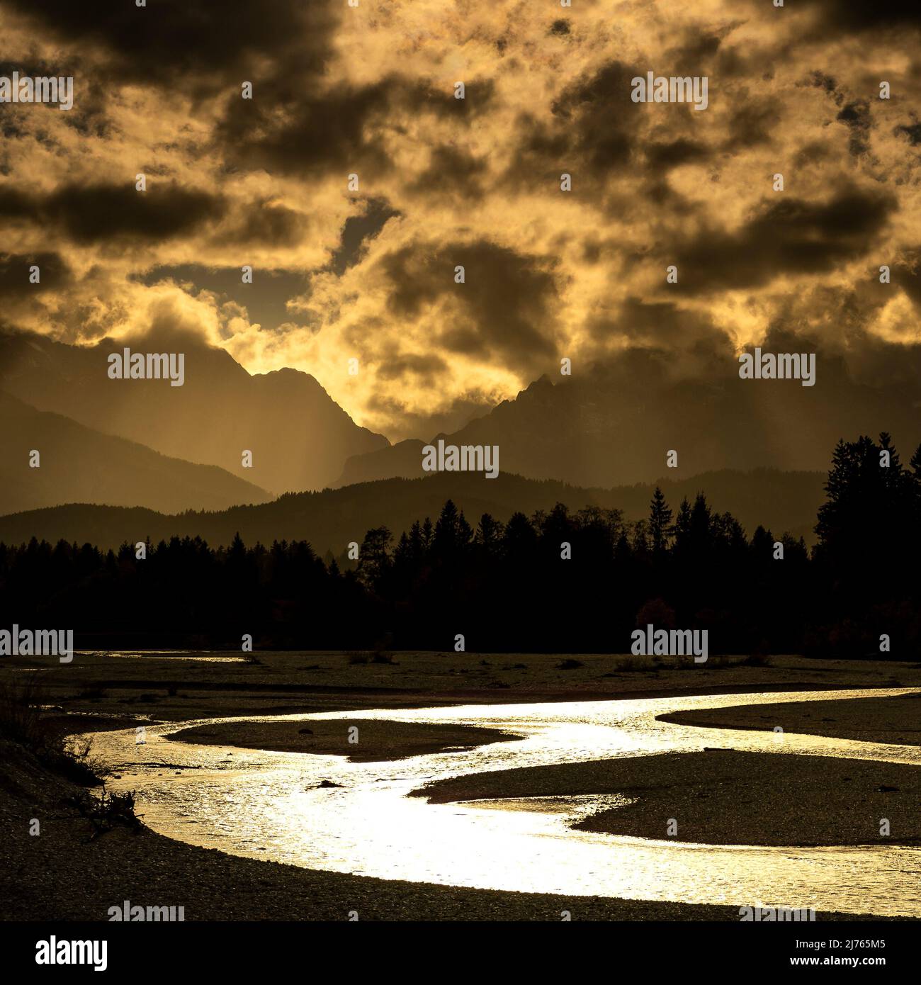 Gloomy, dark cloud atmosphere on the banks of the Isar near Wallgau in ...