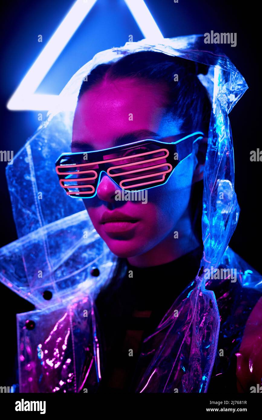 Portrait of confident attractive cyber girl in vinyl hooded jacket and ...