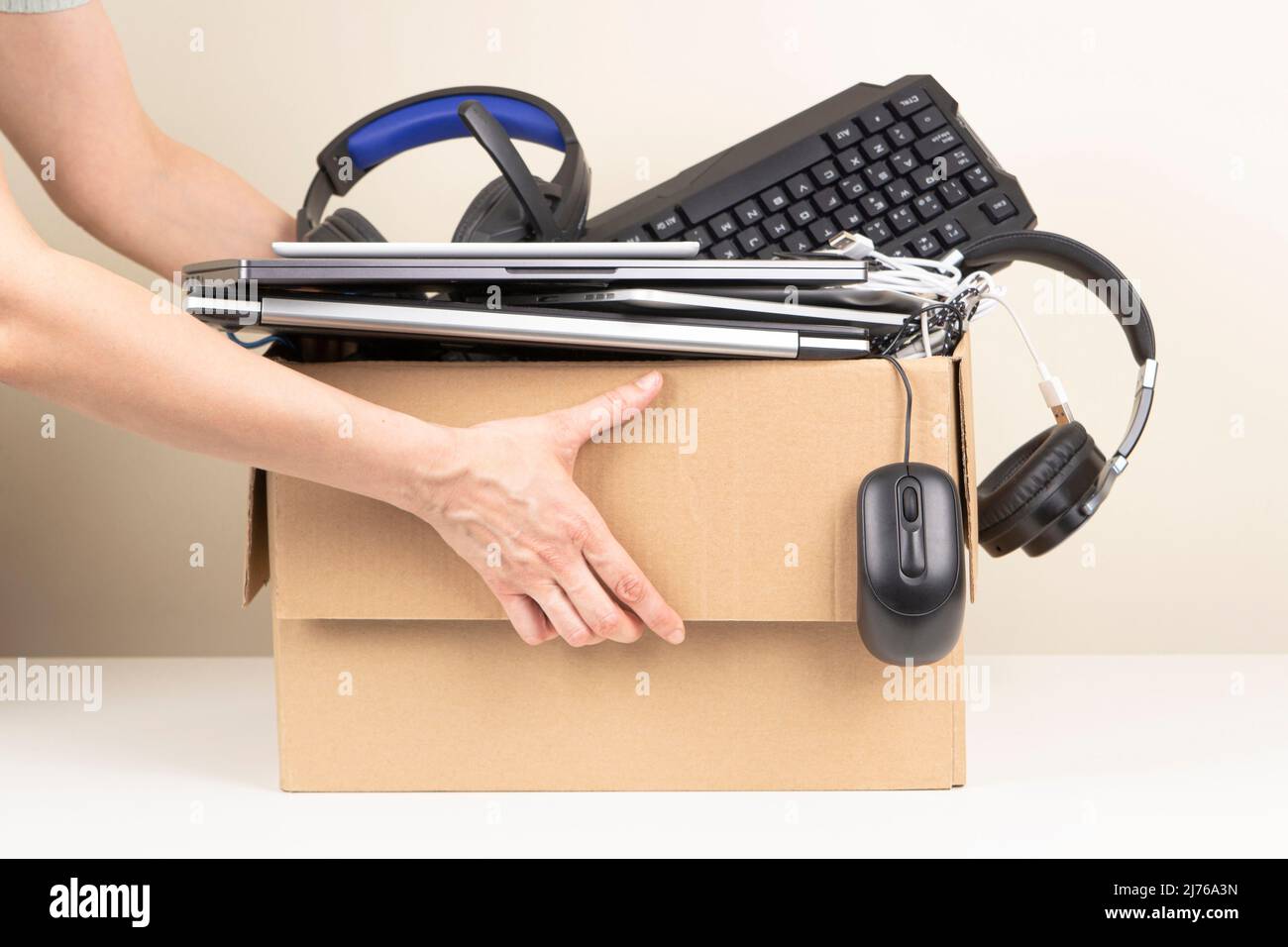 Woman hands holding cardboard box full old used computers, phones ...