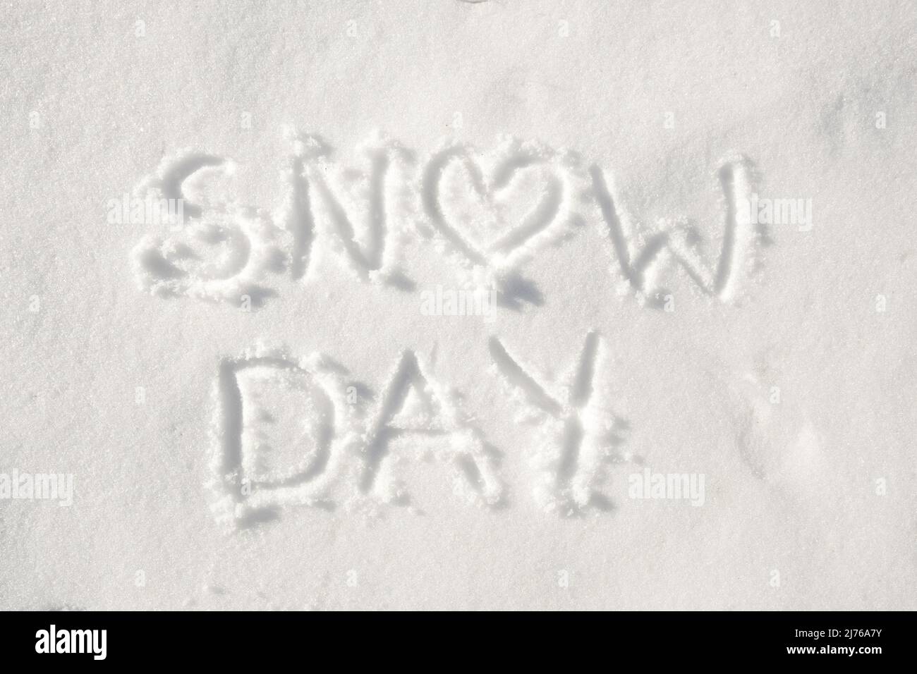 Text "snow day" written in snow, with a heart for letter o; concept of ...
