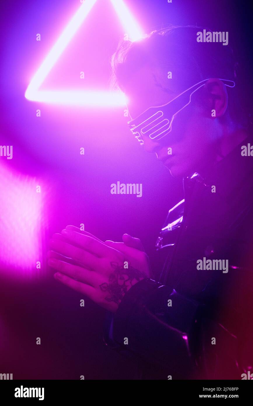 Side view of pensive young popular singer being in stage outfit praying ...