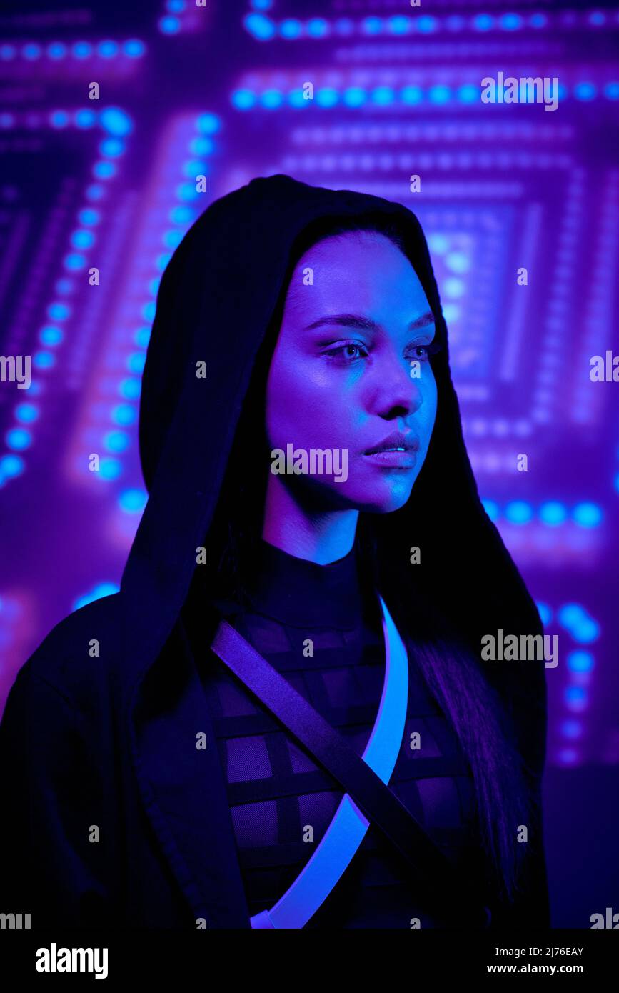 Serious attractive female video game character in hood standing against ...