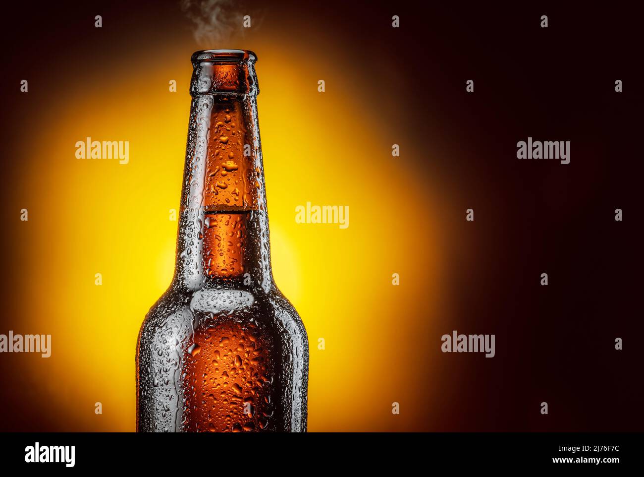 Opened bottle of cold beer and gas output isolated on a yellow ...