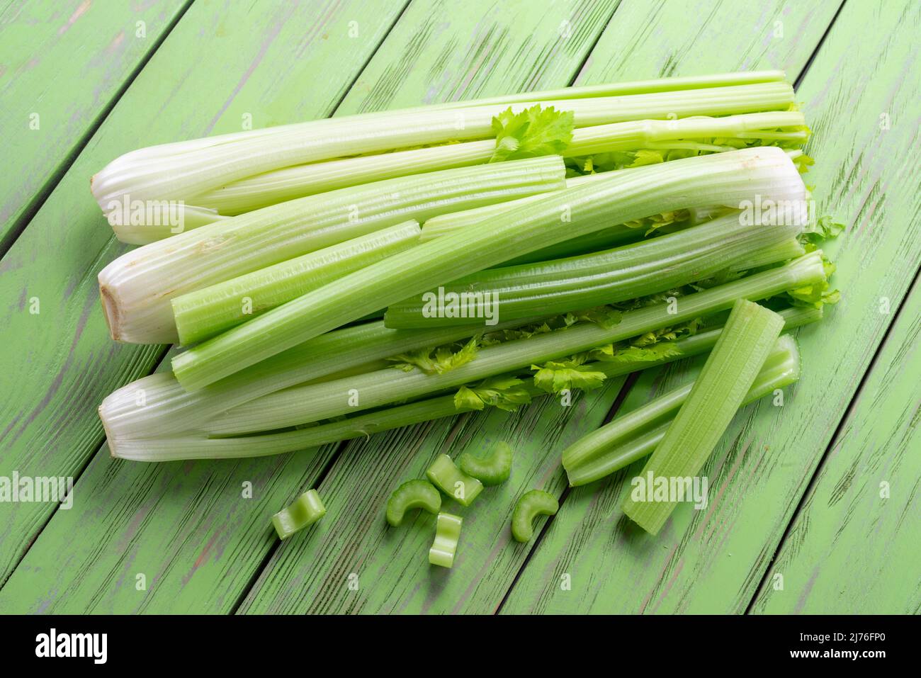 Pile of celery ribs on green wooden table. Healthy food background ...