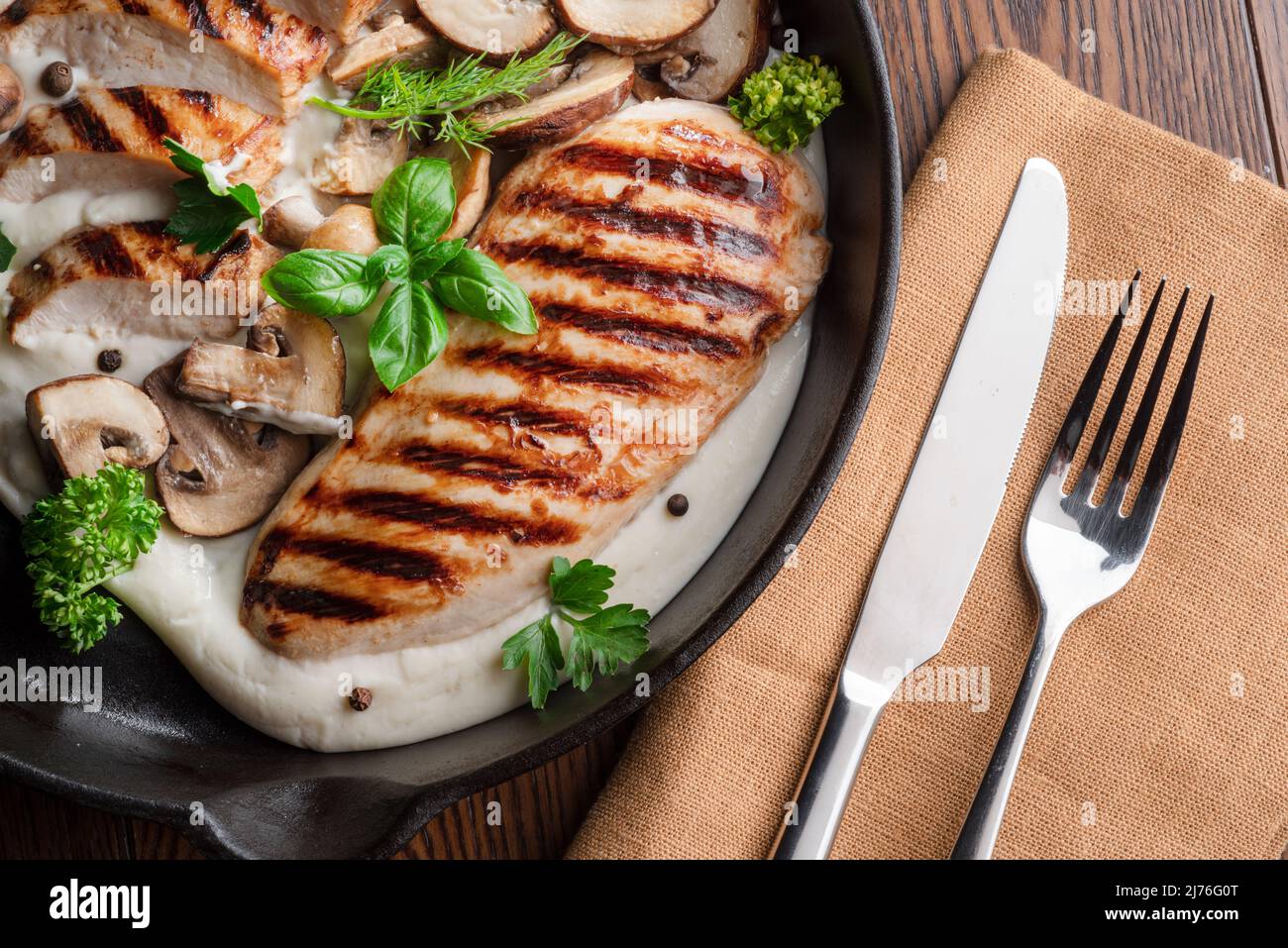 Roasted chicken fillet and mushrooms with herb in the frying pan on the ...