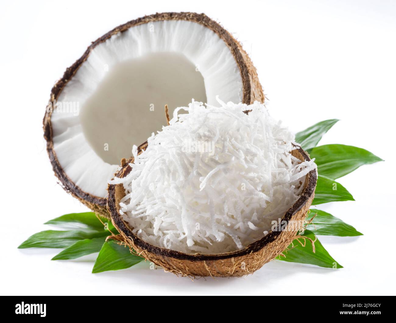Cracked coconut fruit with white flesh and shredded coconut flakes ...