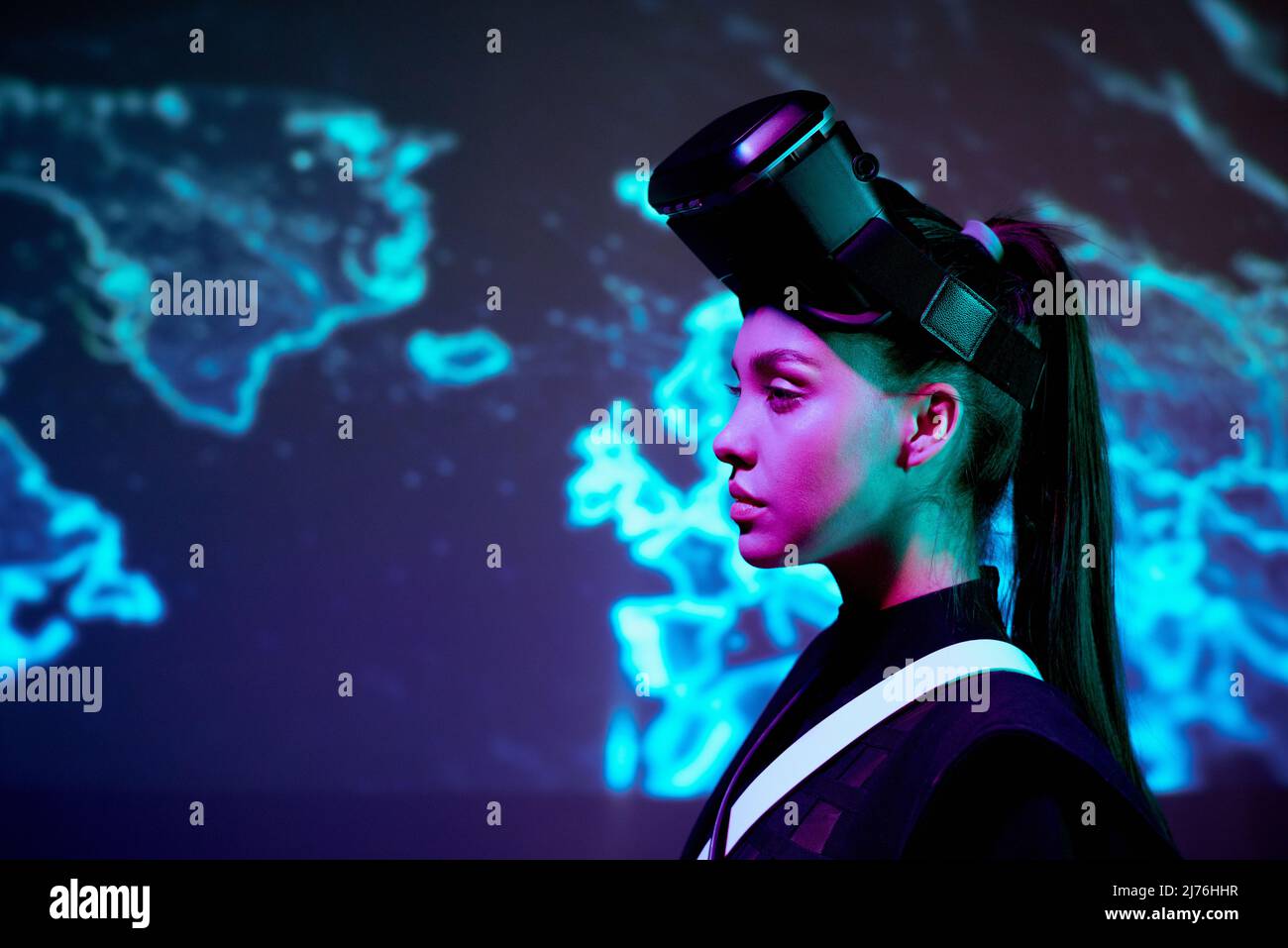 Side view of serious young woman with VR headset making discovery with ...