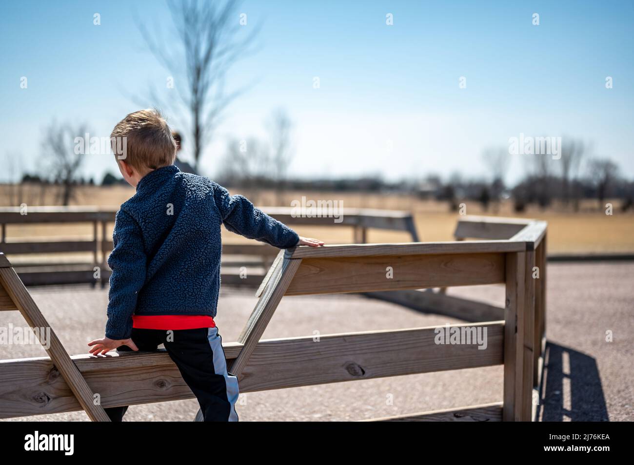 Child waiting along fence for next round of gaga ball in a school ...