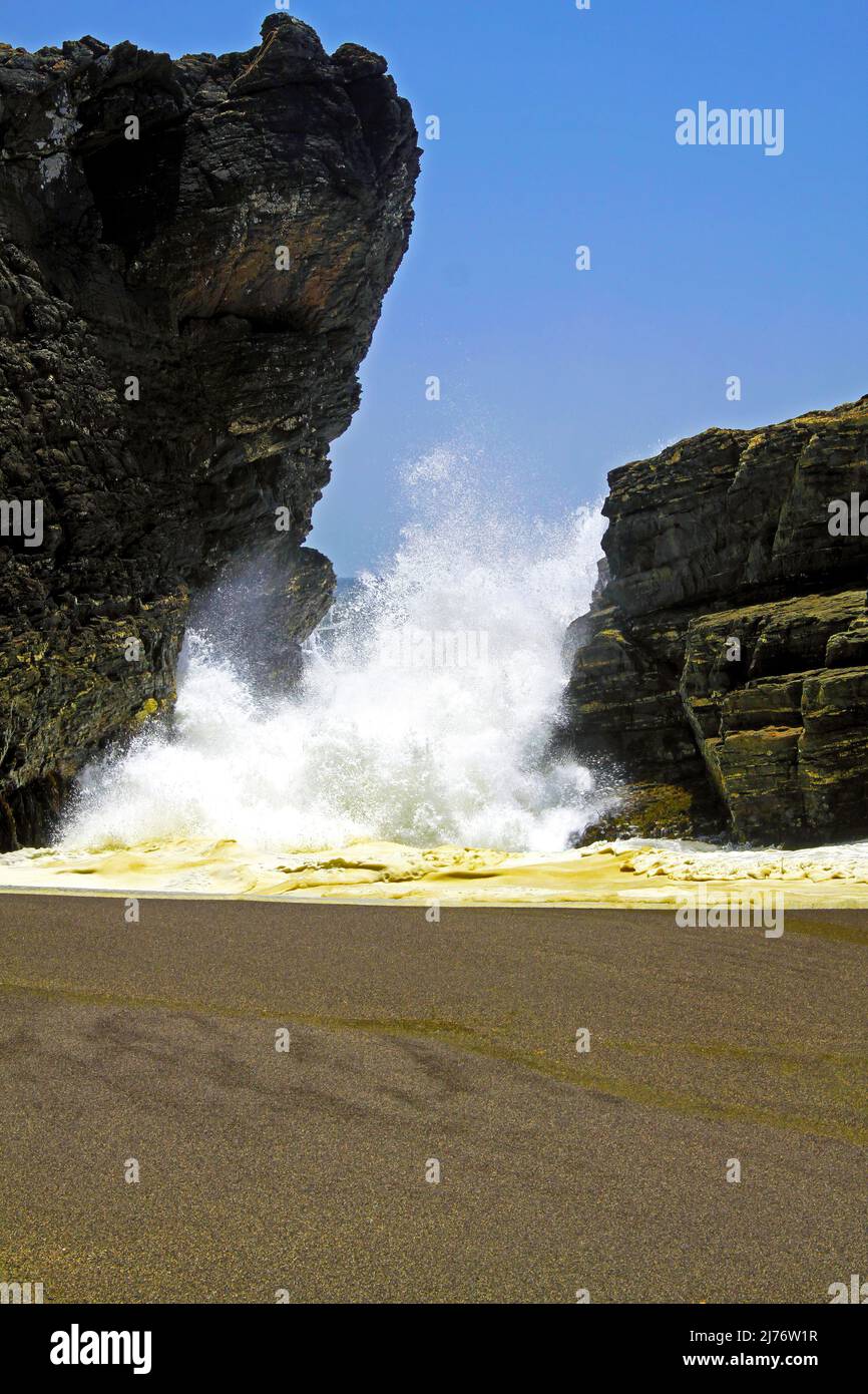 Secluded black lava sand beach cove, powerful heavy violent surf waves ...