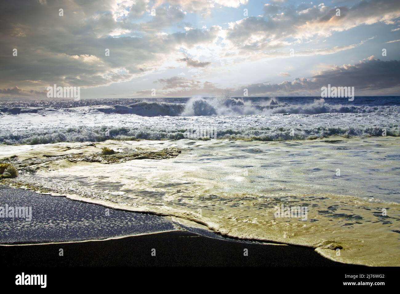 Beautiful rough ocean landscape, black lava sand beach, foamy white ...