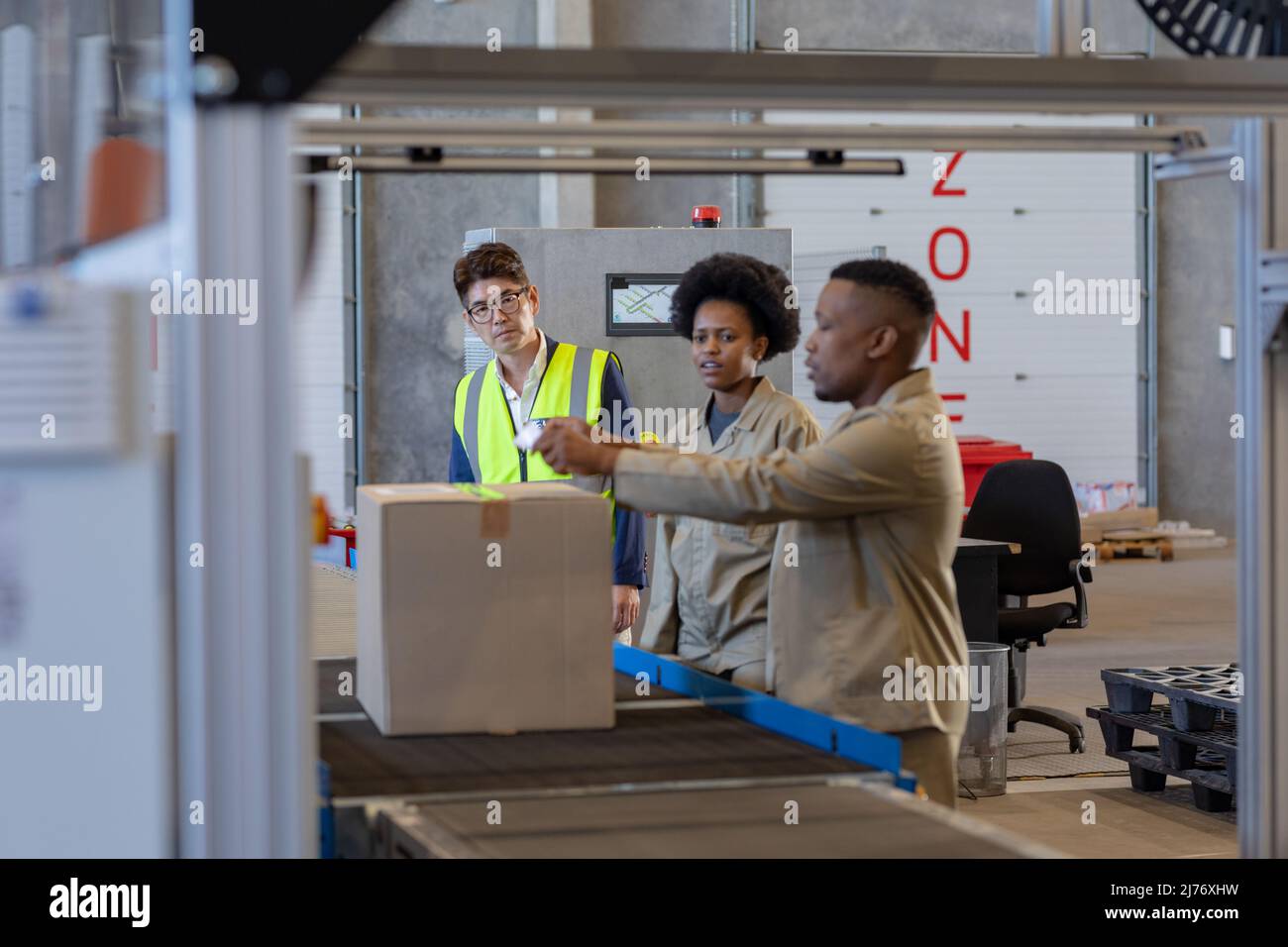 Asian man inspecting african american workers scanning barcode of ...