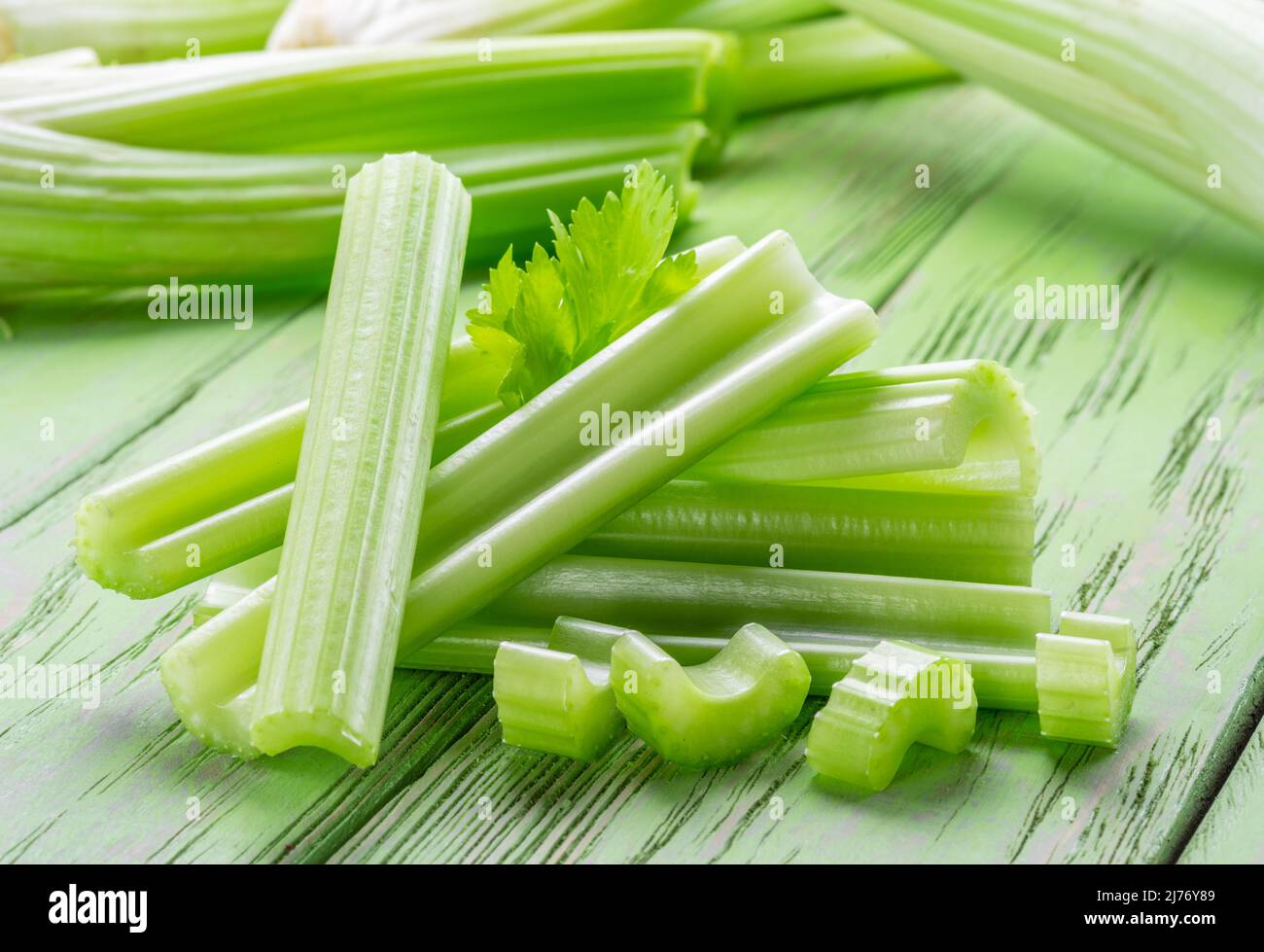 Pile of celery ribs on green wooden table. Healthy food background ...