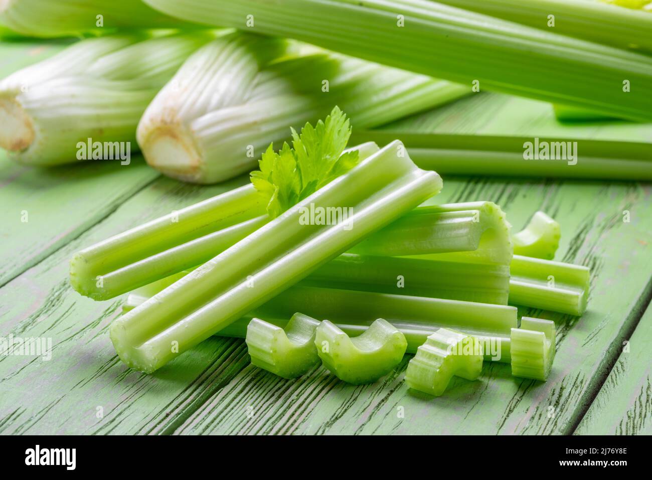 Pile of celery ribs on green wooden table. Healthy food background ...