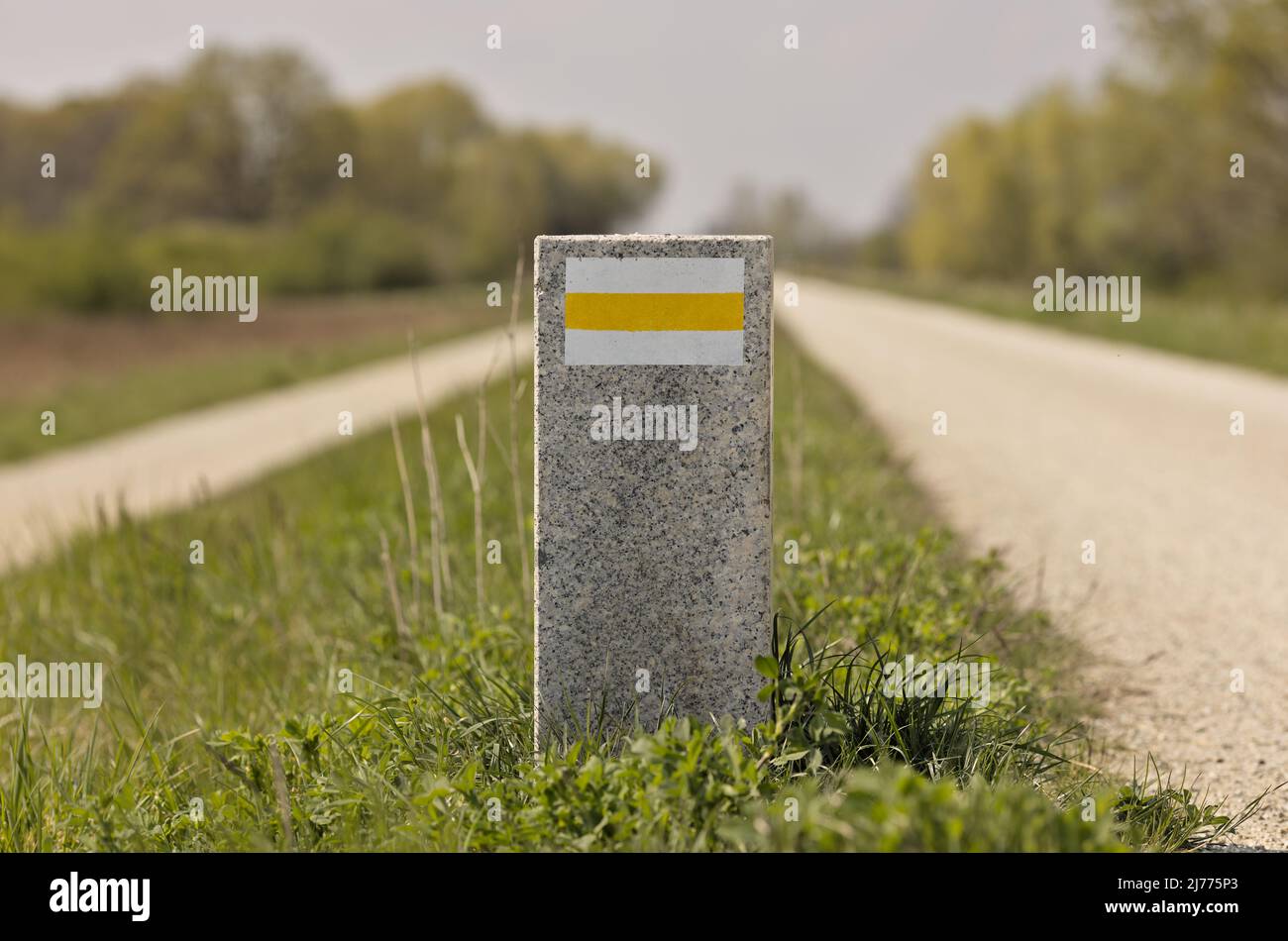 White and yellow trail marker painted on a granite post Stock Photo - Alamy