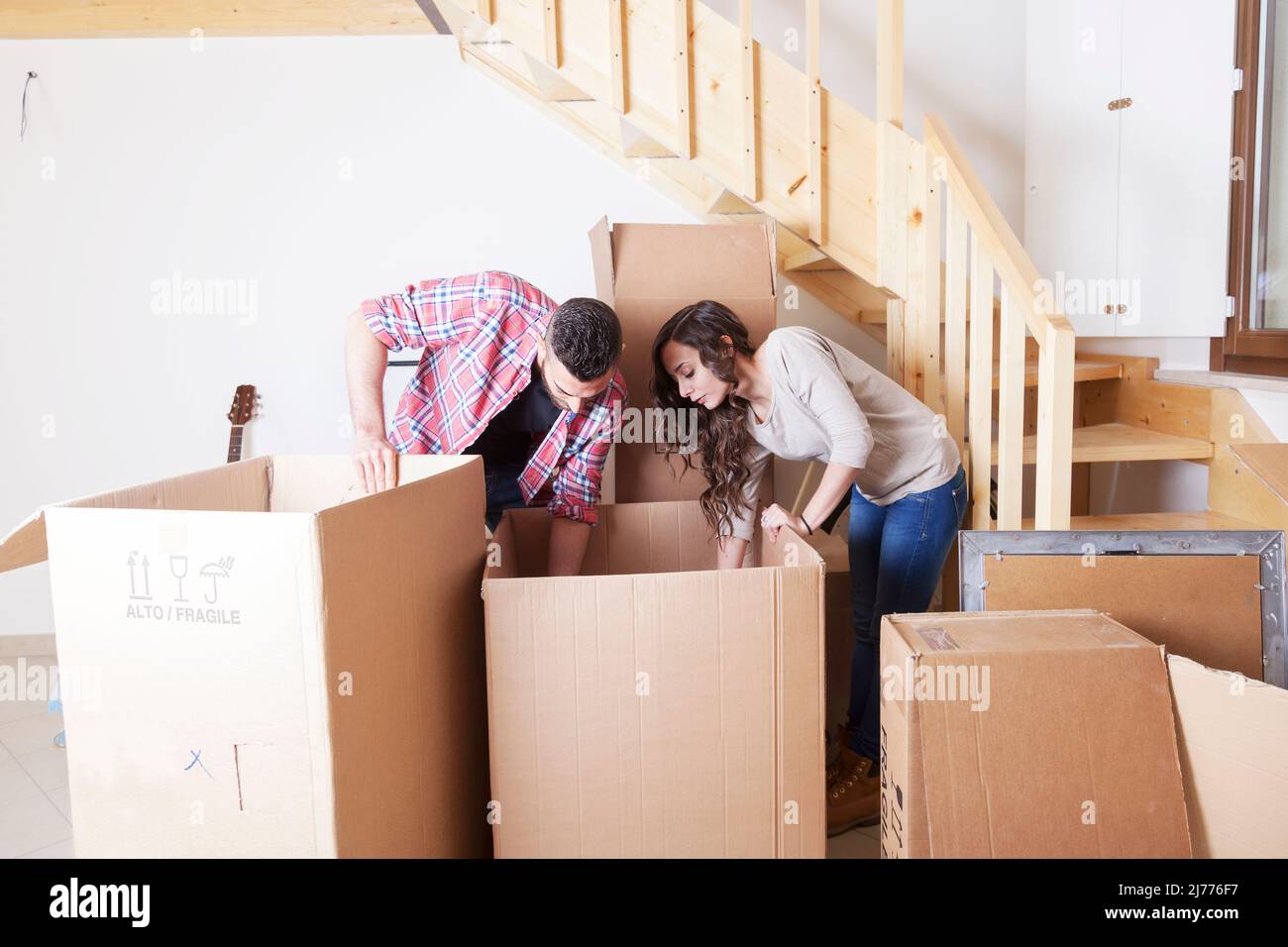 young couple opened the boxes for the new house Stock Photo - Alamy