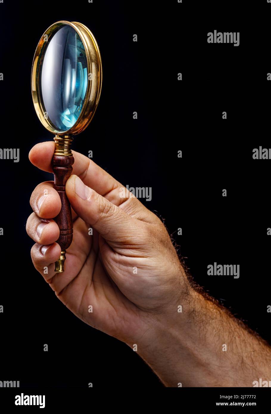 Old fashioned handle magnifier or hand lense in man's hand isolated on ...
