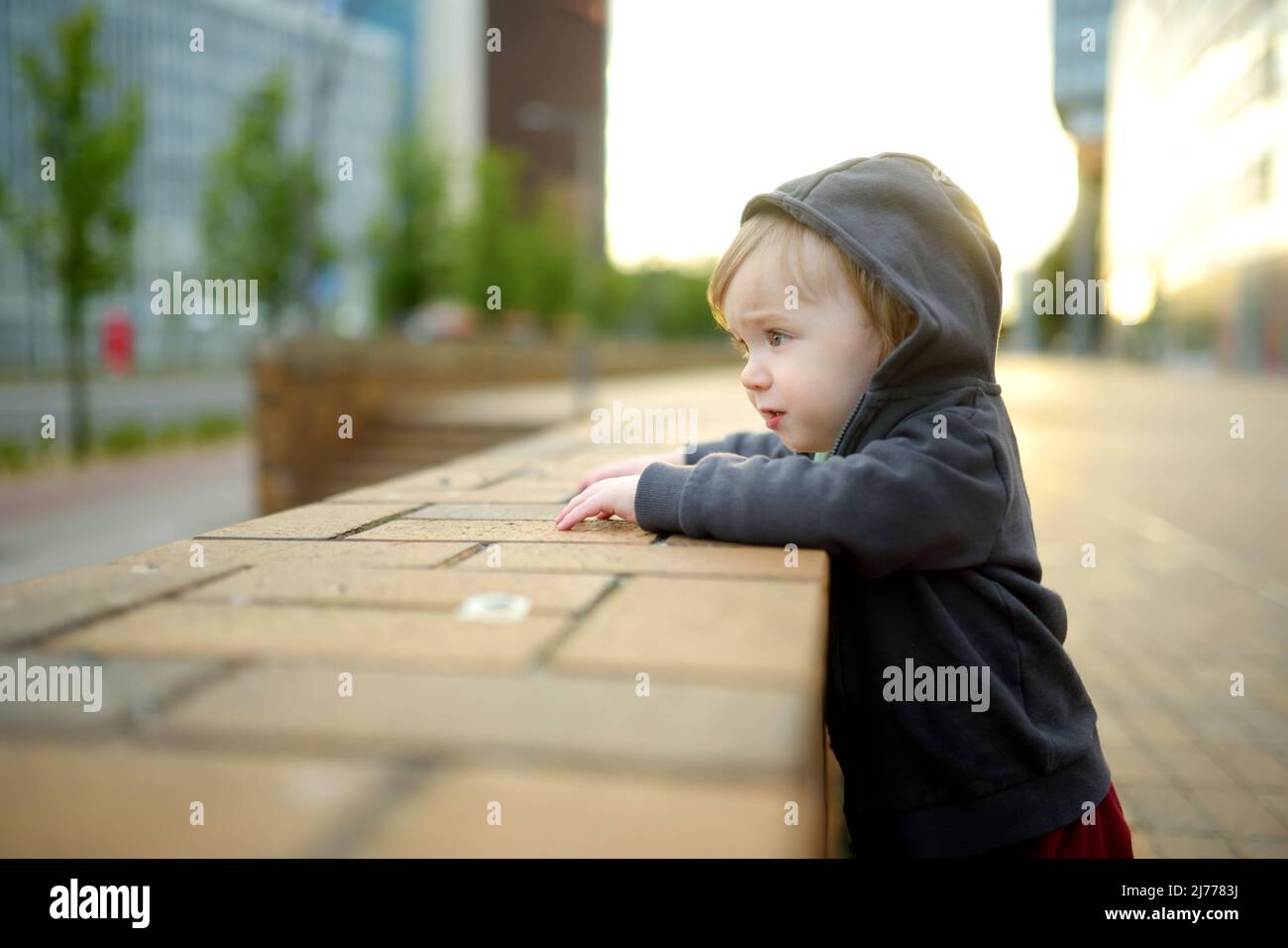 Funny toddler boy having fun in the city on sunny summer day. Outdoor ...