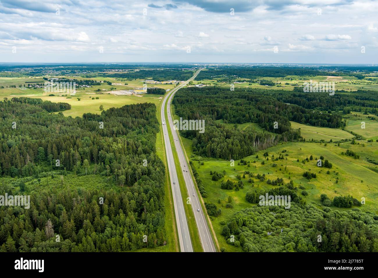 Aerial top down view of summer forest with two-lane road among pine ...