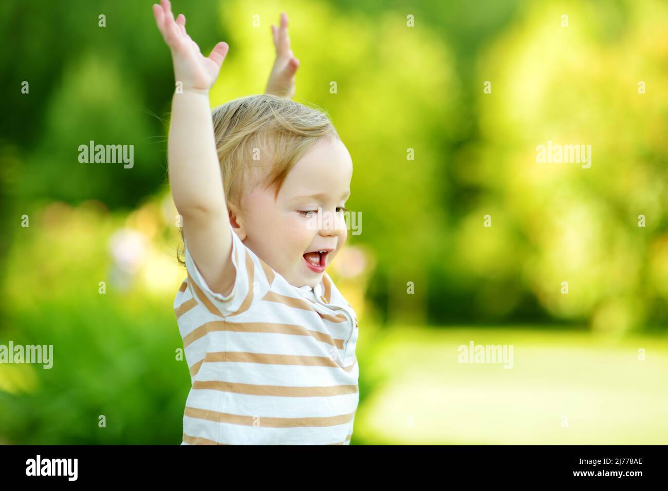 Funny toddler boy having fun outdoors on sunny summer day. Child ...