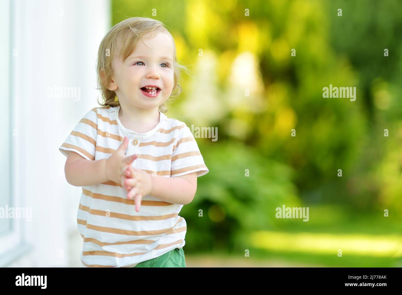 Funny toddler boy having fun outdoors on sunny summer day. Child ...