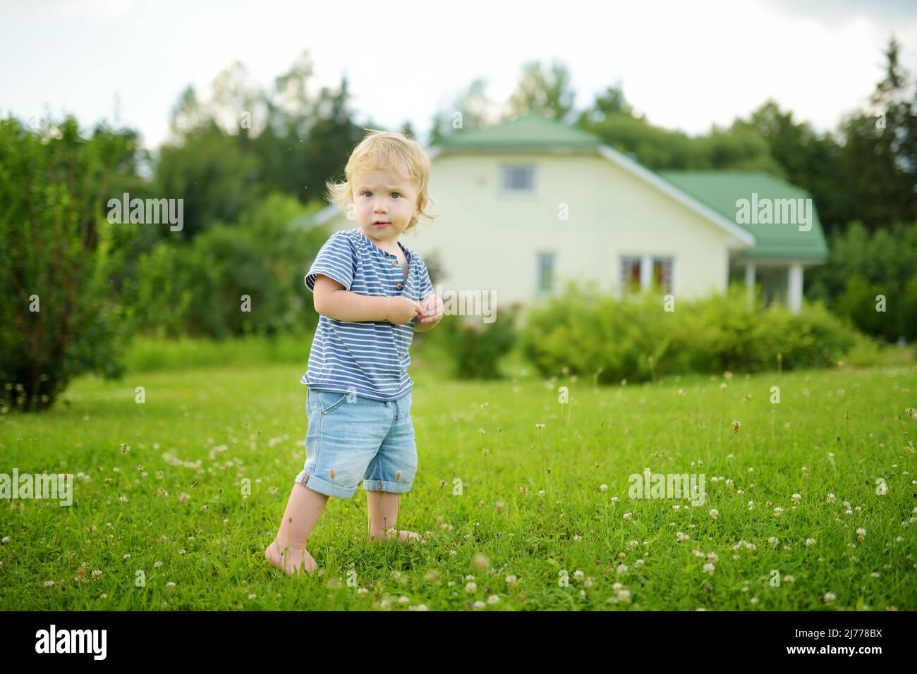 Funny toddler boy having fun outdoors on sunny summer day. Child ...