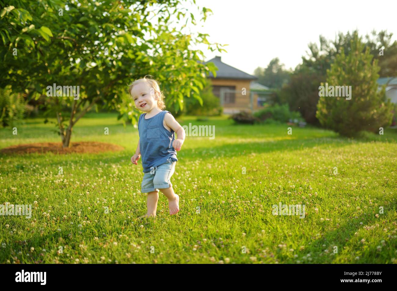Funny toddler boy having fun outdoors on sunny summer day. Child ...