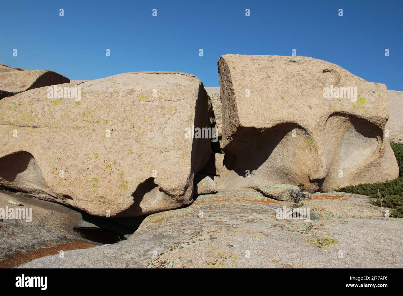 A huge round volcanic white stone split in half on the rocks in the ...