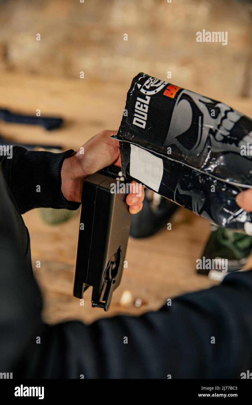 Man's hands reloading the airsoft gun with balls Stock Photo - Alamy