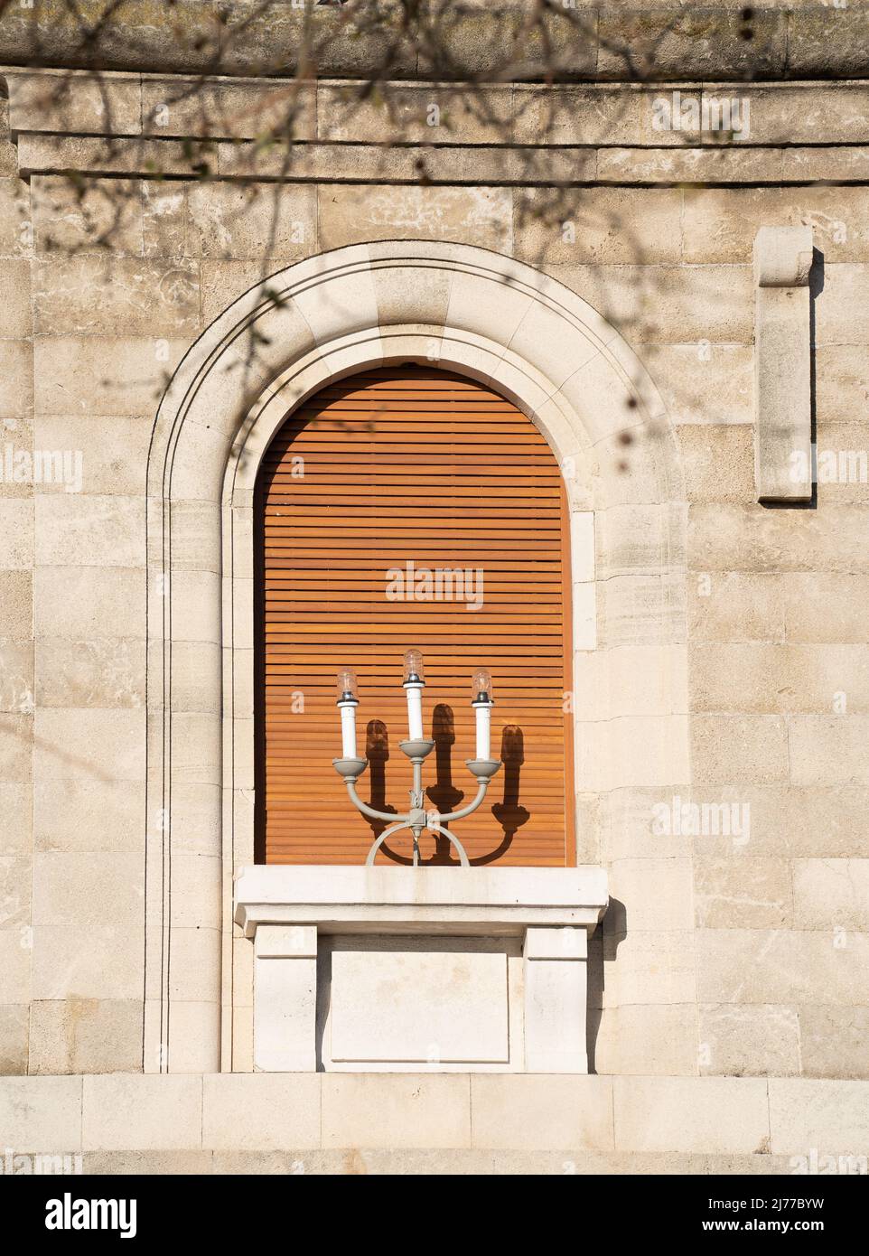 Three candlestick in front of a window with closed window shutters ...
