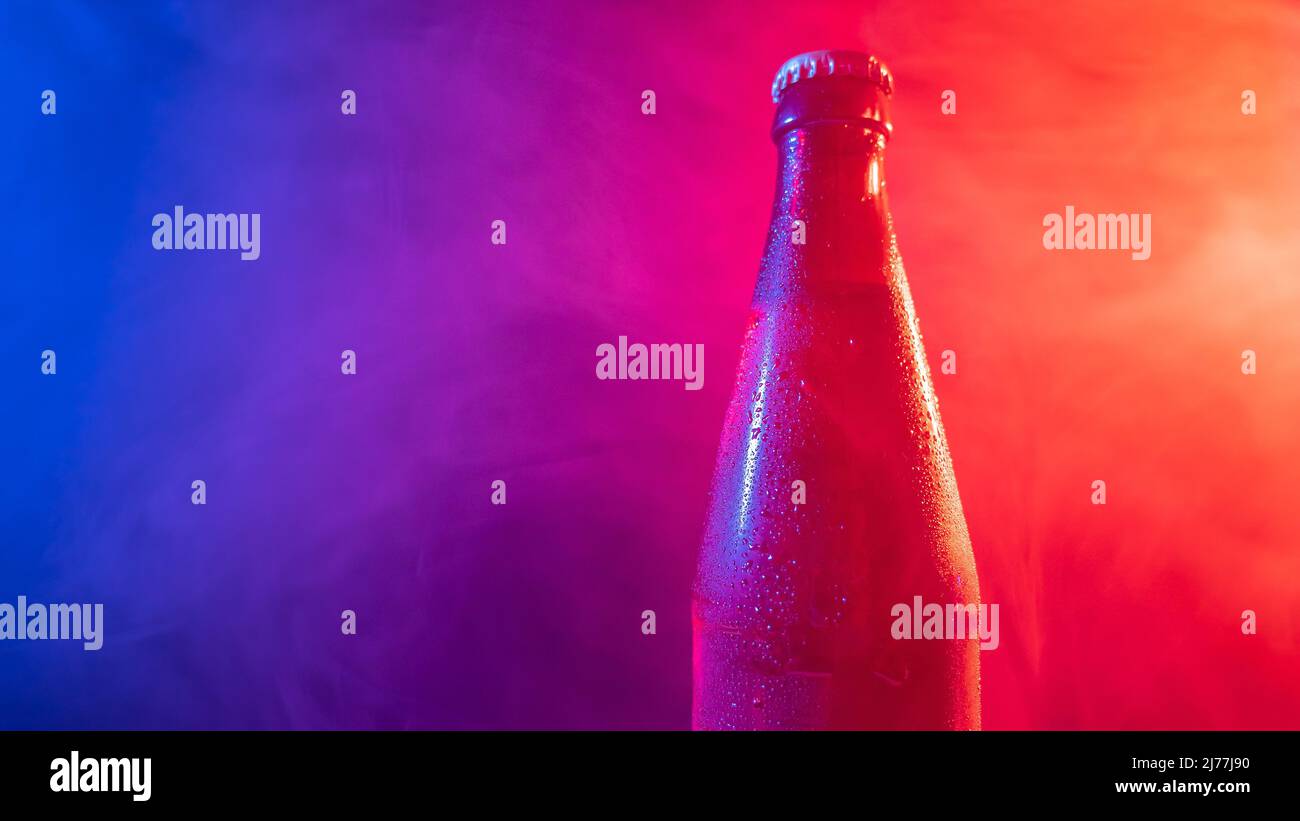 Glass bottle of beer in blue pink mist Stock Photo - Alamy
