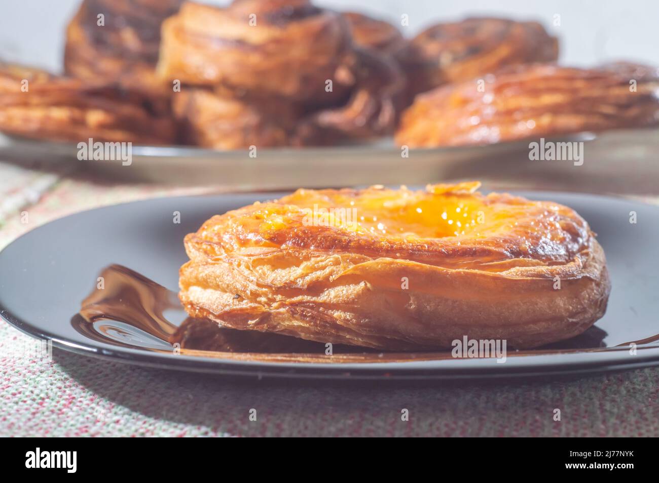 Sweet puff pastry stuffed with apricot and peach on a black dish with ...