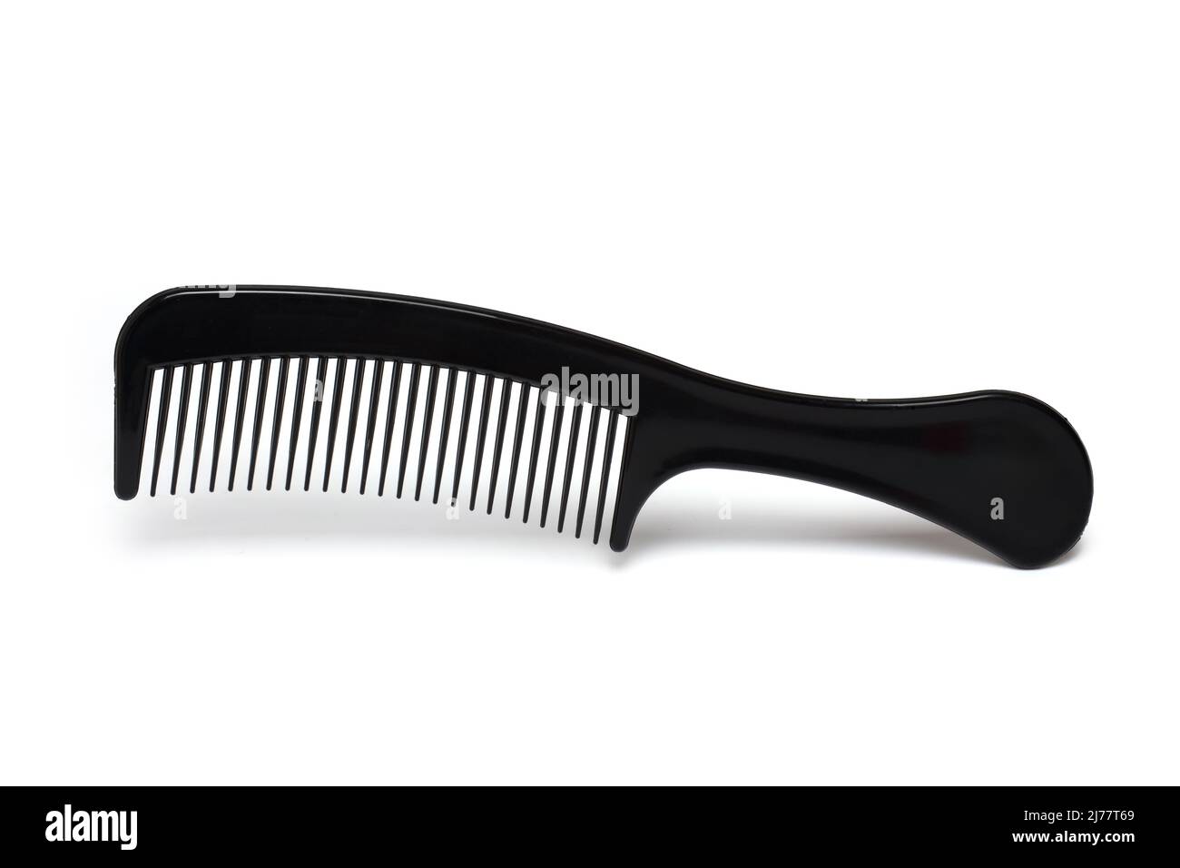 Close up of black comb for straightening long hair with round handle on ...