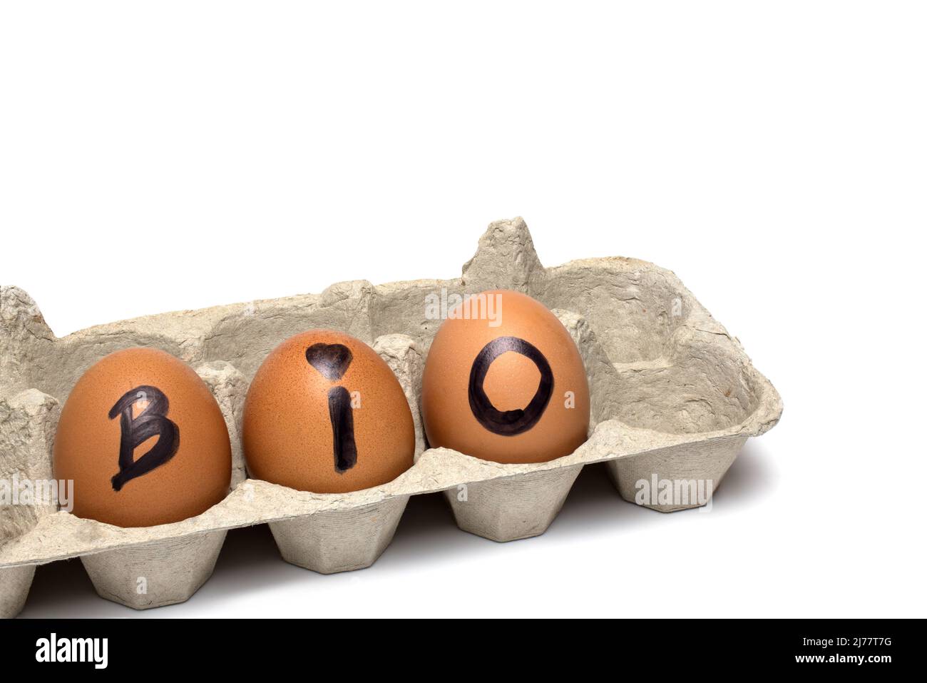 Close up of three brown eggs in an uncolored recycled gray cardboard ...