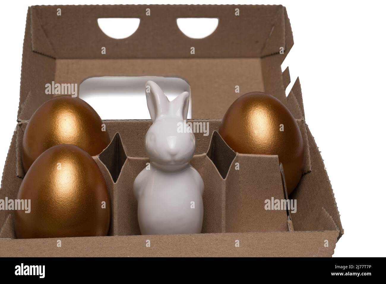 Close up of open egg carton box with three golden colored eggs and ...