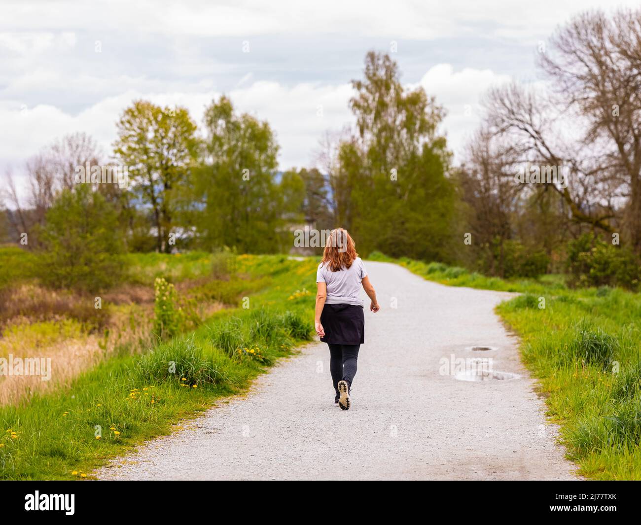 Woman walking in spring forest nature path walk on trail woods ...