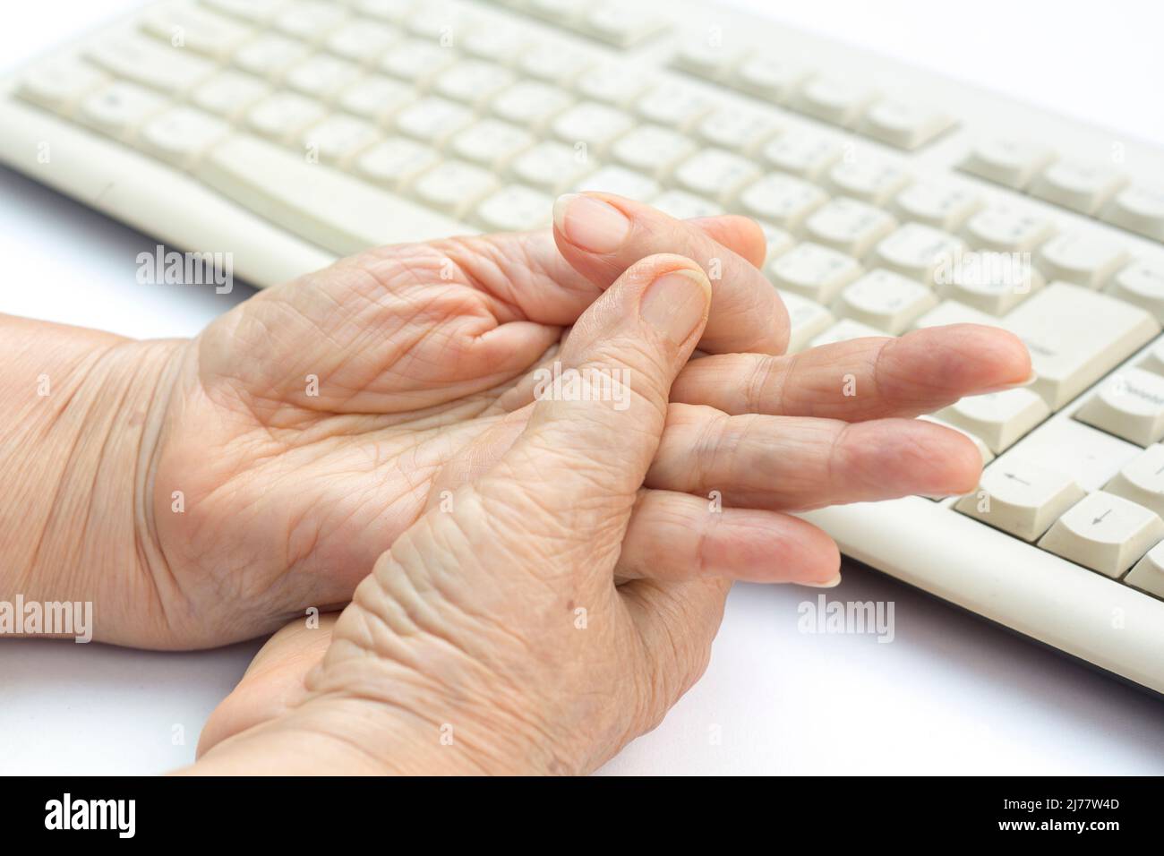 Senior woman painful finger due to prolonged use of keyboard and mouse ...