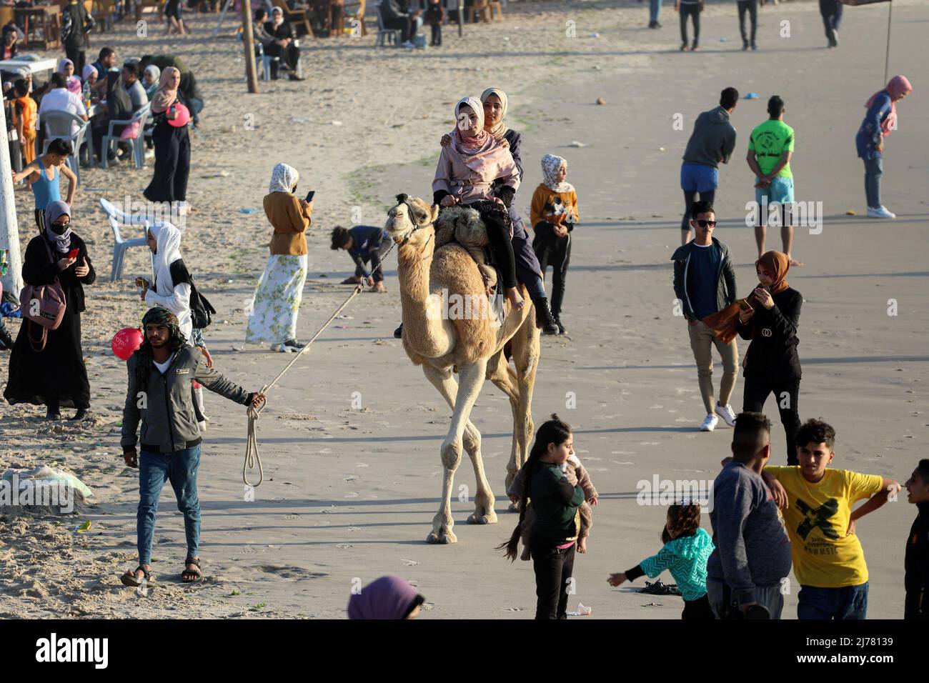 Palestinians enjoy the sun and the warm weather at the Gaza beach on ...